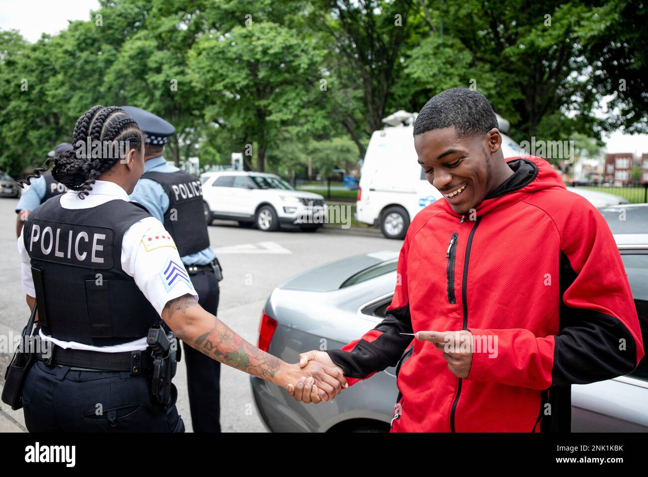 A police officer shake hands with Anthony Perry, 20, after Early Walker ...