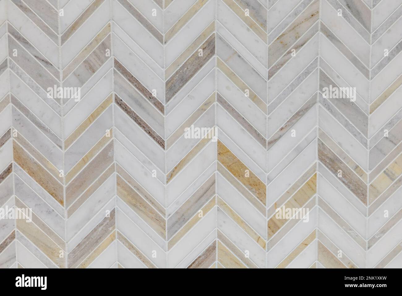 White, gray and brown marble herrinbone tile on a bathroom wall or ...
