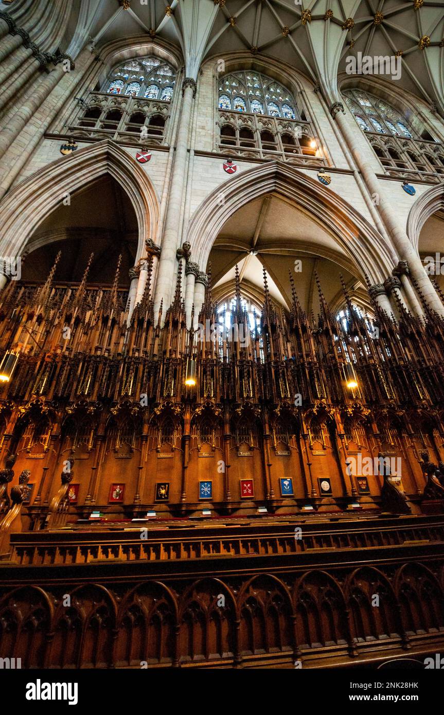 Gothic windows and pointed arches tower behind carved wood prebendal ...
