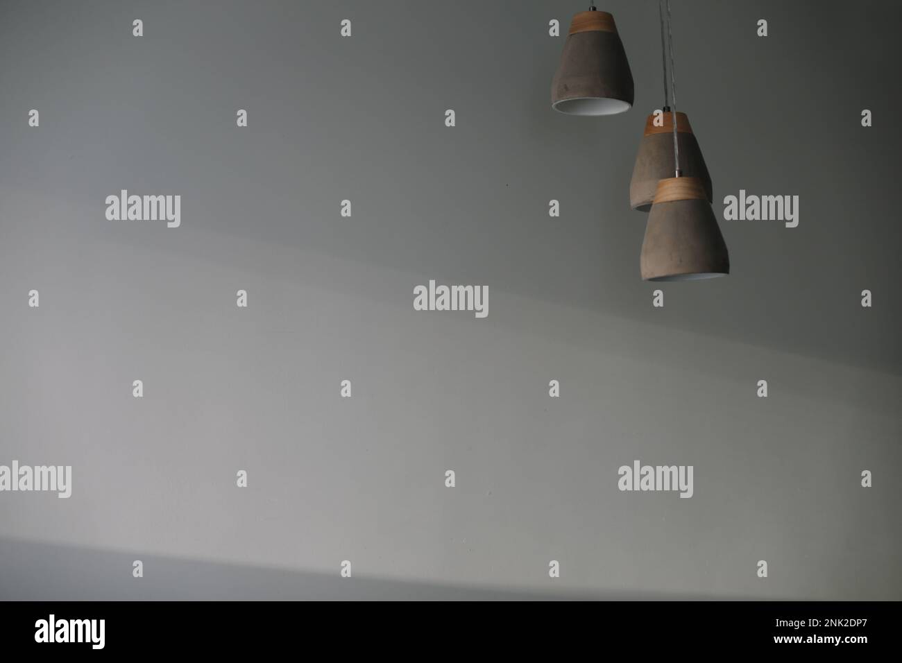 Fancy hanging lamps with wooden parts on the white wall background ...