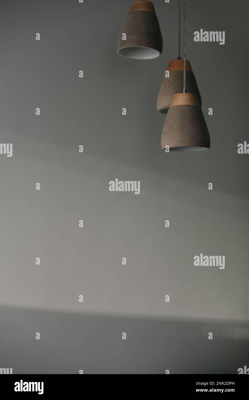 Fancy hanging lamps with wooden parts on the white wall background ...