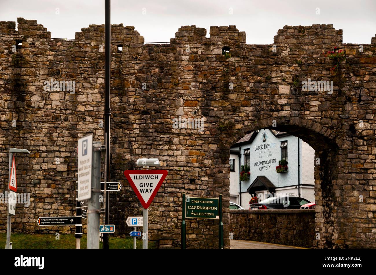 Town walls and arched entrance gate of Edwardian style Caernarfon ...