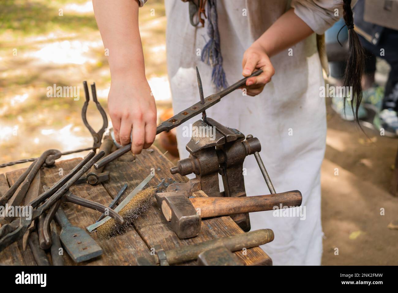 Professional blacksmith woman working with metal on anvil - close up ...