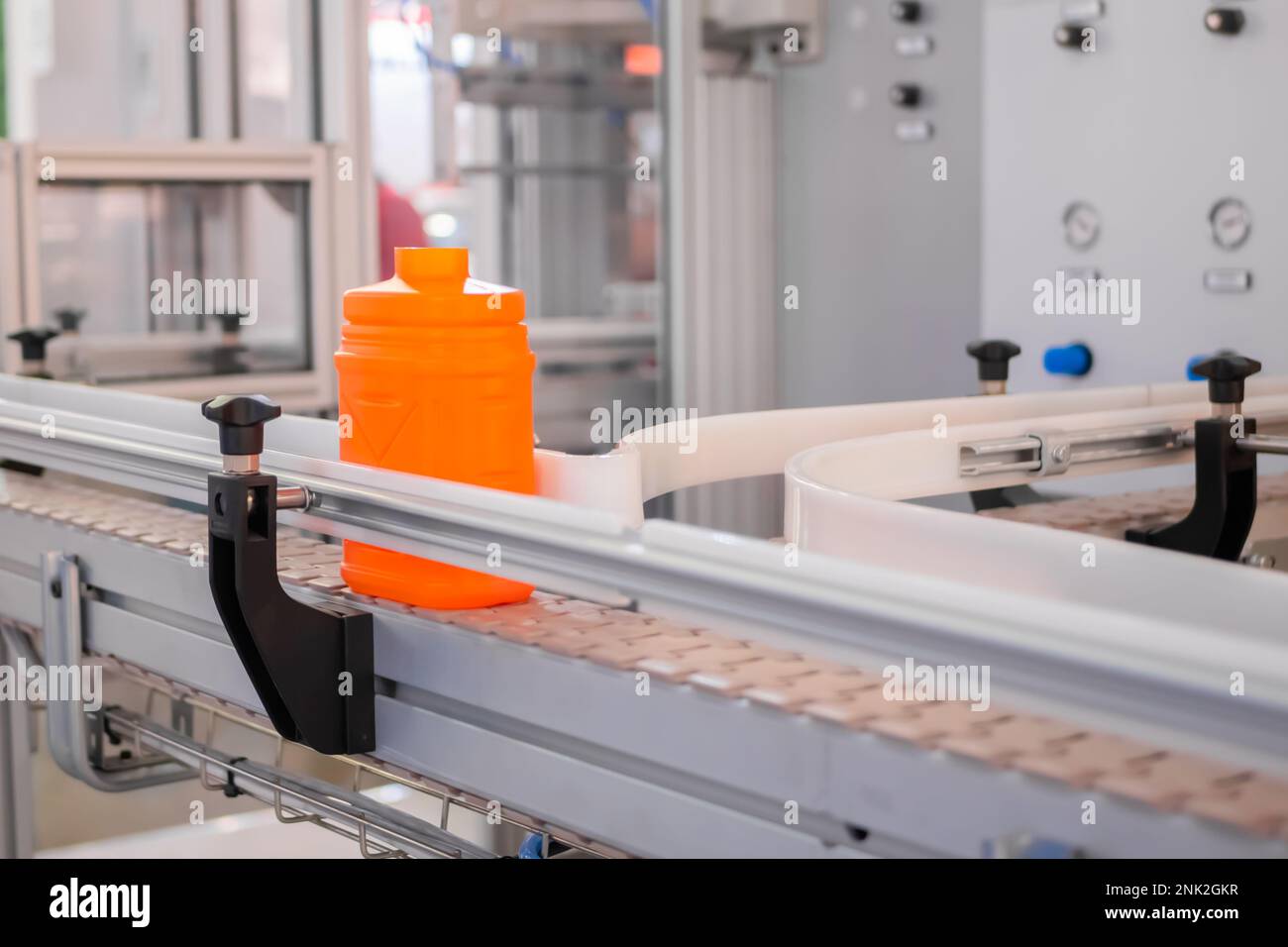 Empty orange plastic jerry can moving on conveyor belt at exhibition ...