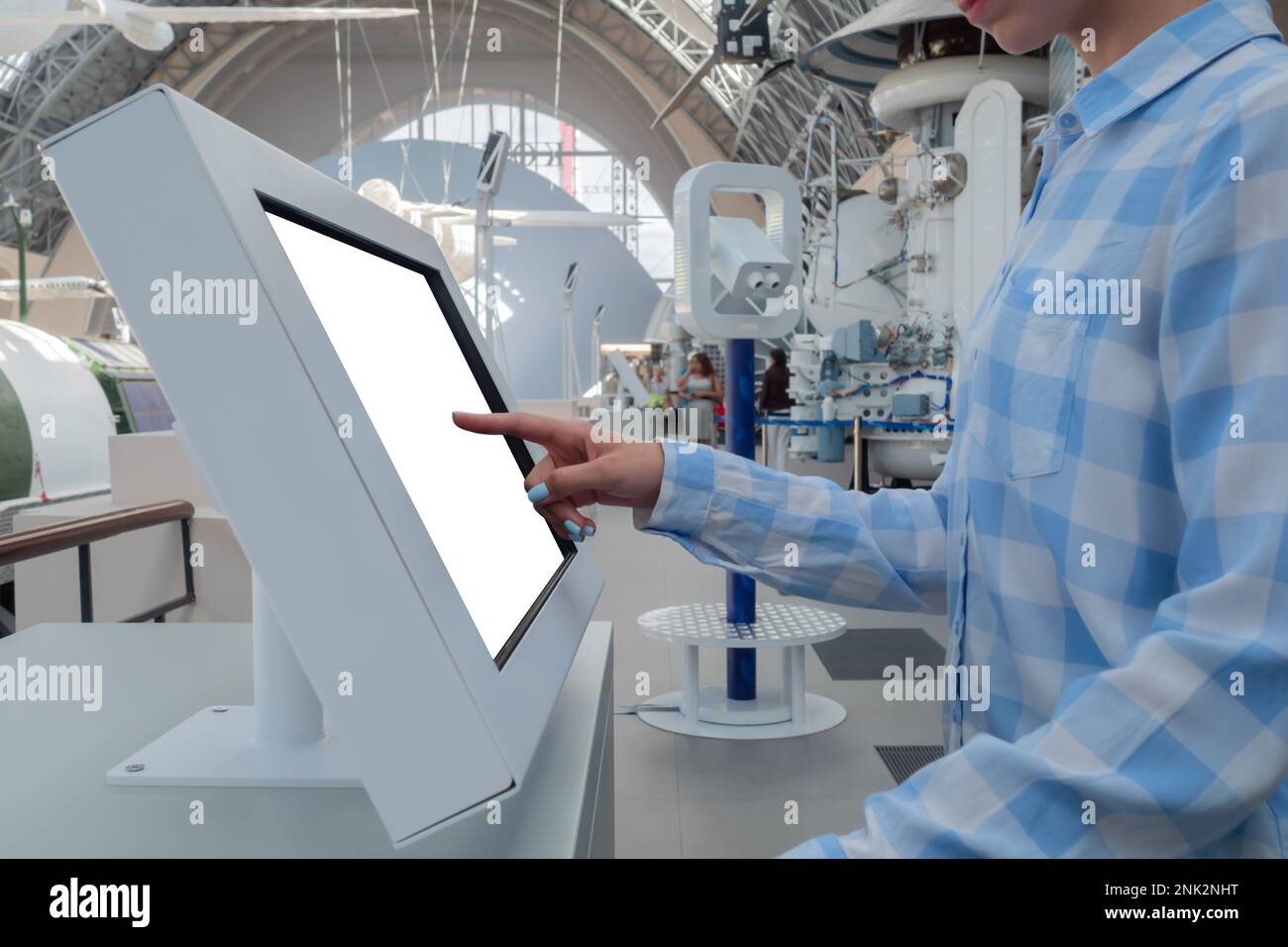 Woman hand touching interactive white touchscreen display kiosk: close ...