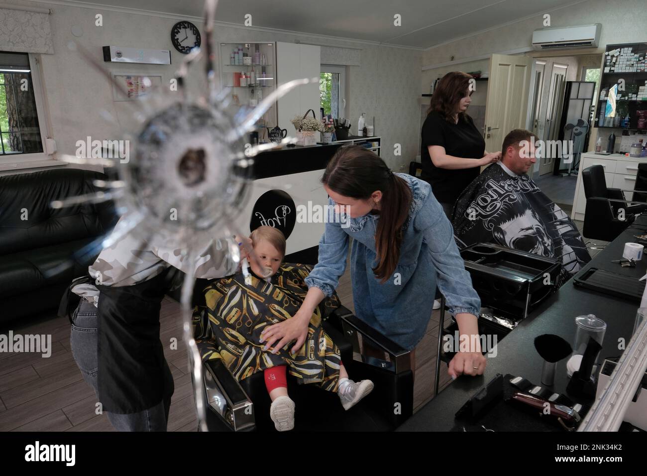 A child gets his hair cut at a barber in Bucha, Kyiv Oblast on June 1 ...