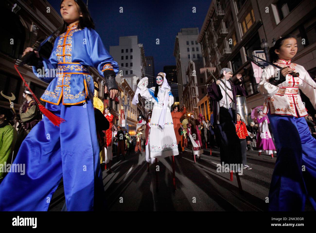 Mayra Chang, (center) dressed as the Goddess of Mercy walks on stilts ...