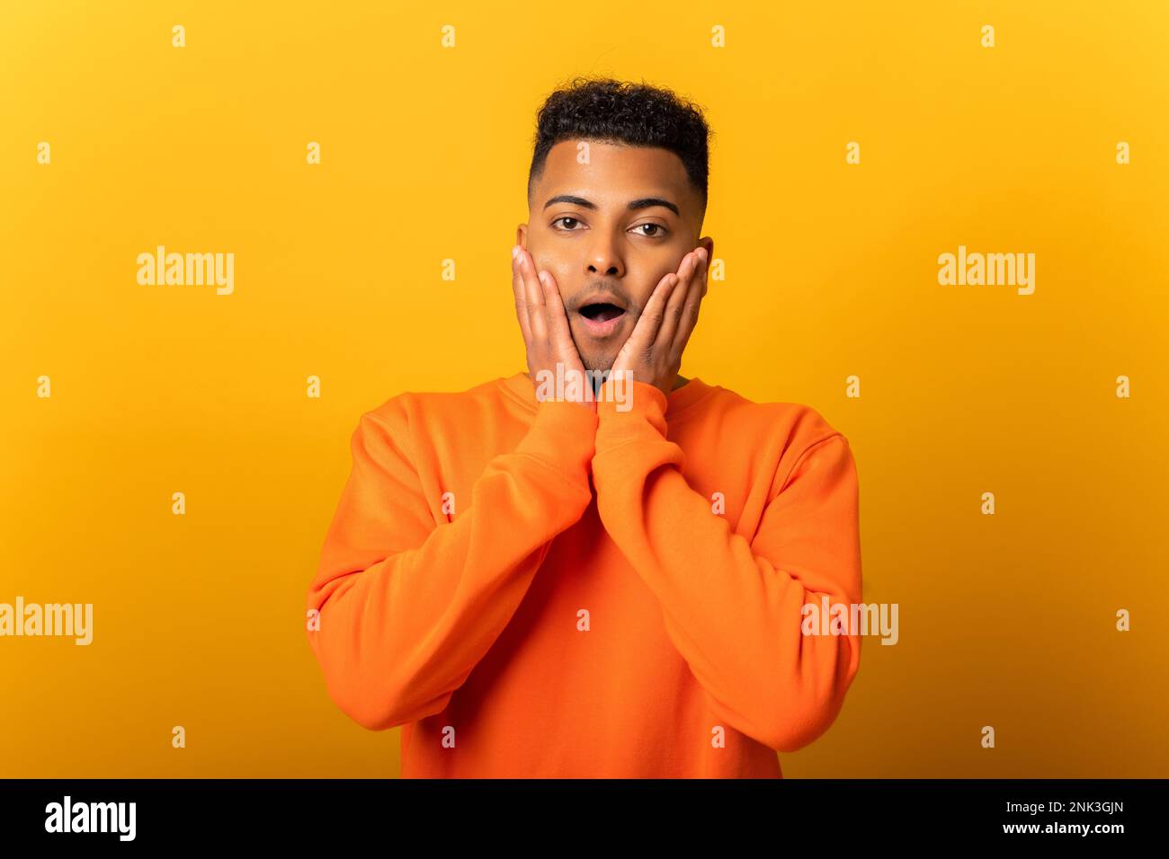 Serious shocked man holding hands on face and screaming looking at ...