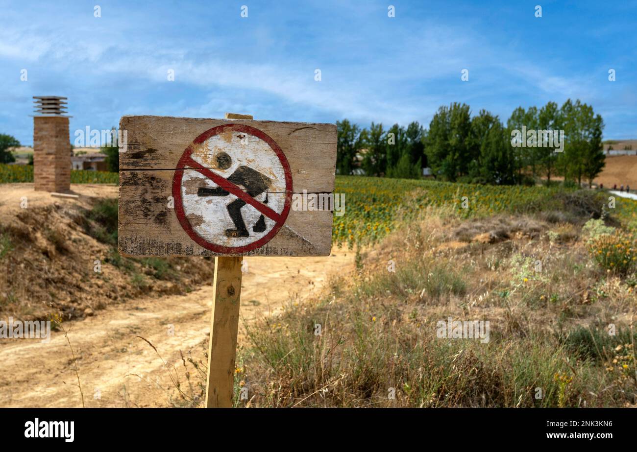 A weathered wooden sign with a hand-painted red circle and a stick ...