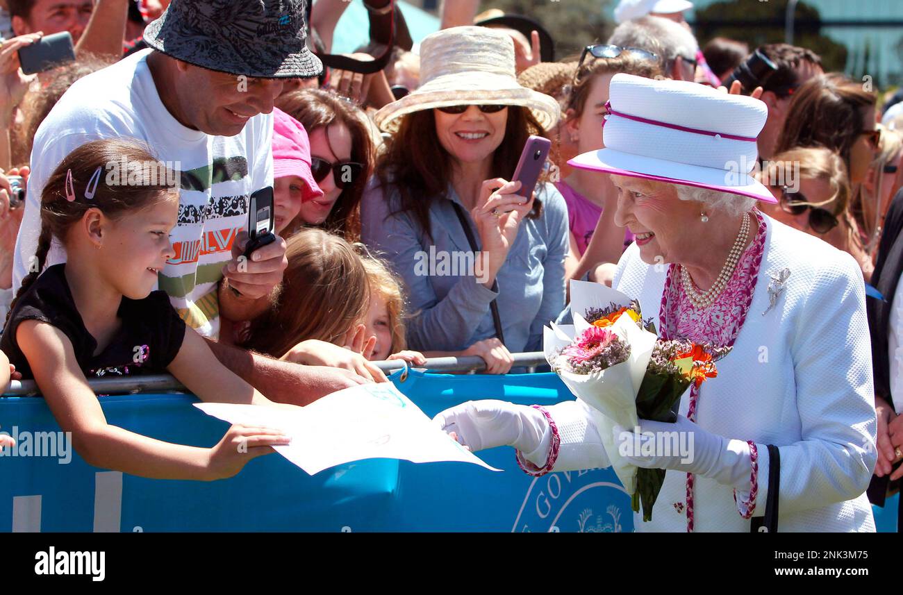 FILE - A young girl gives Queen Elizabeth II a picture she walks ...