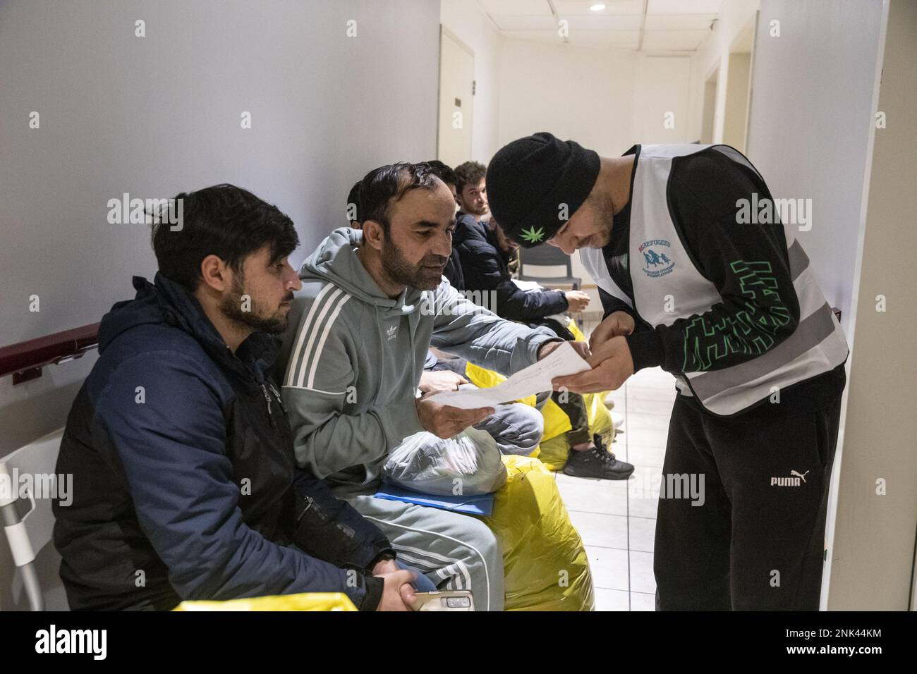 Illustration shows BelRefugees association worker welcome refugees in a ...