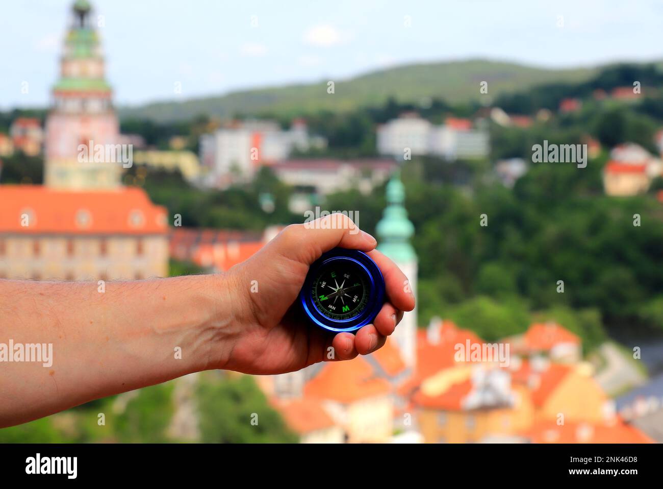 Tourist holds compass against medieval town Cesky Krumlov in Czech ...