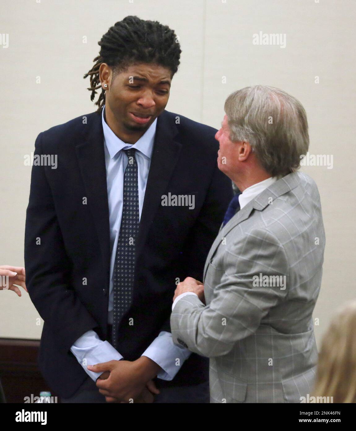 Isimemen Etute, left, and defense attorney Jimmy Turk hug at the ...