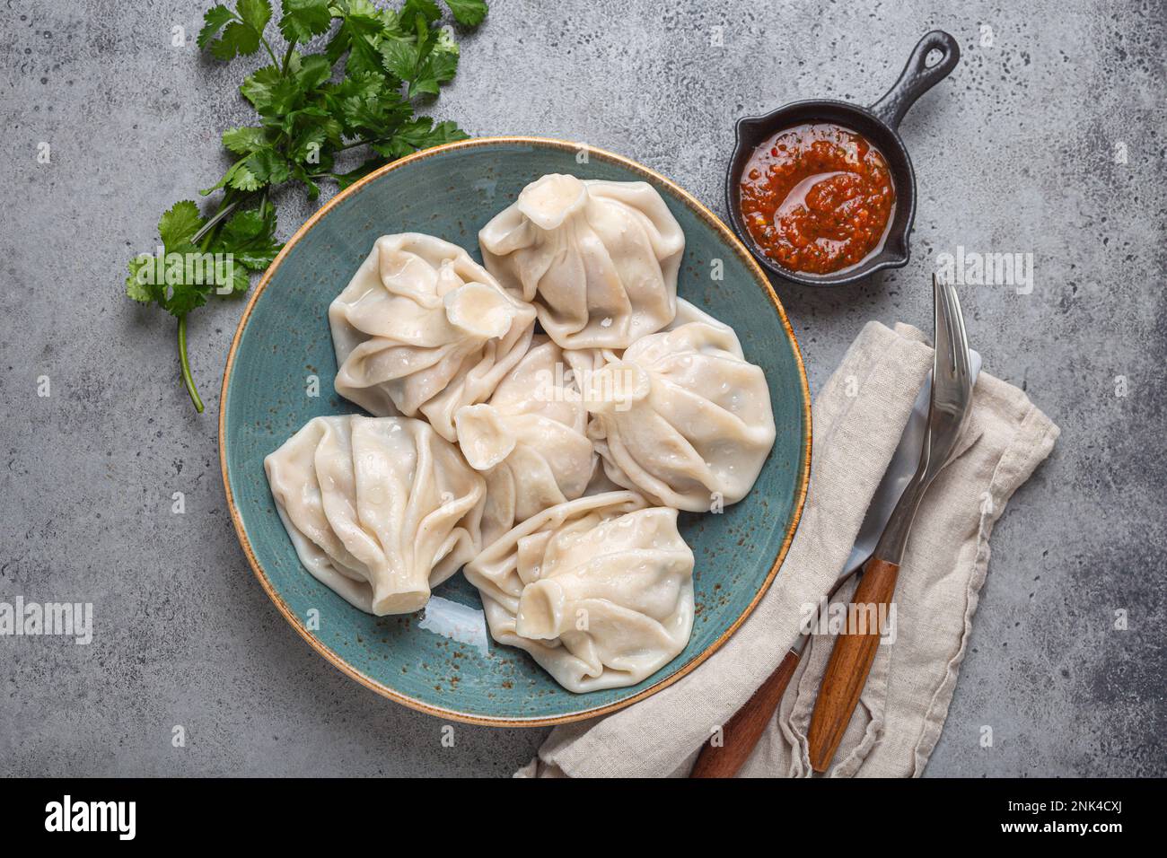 Georgian dumplings Khinkali on plate with red tomato sauce and fresh ...