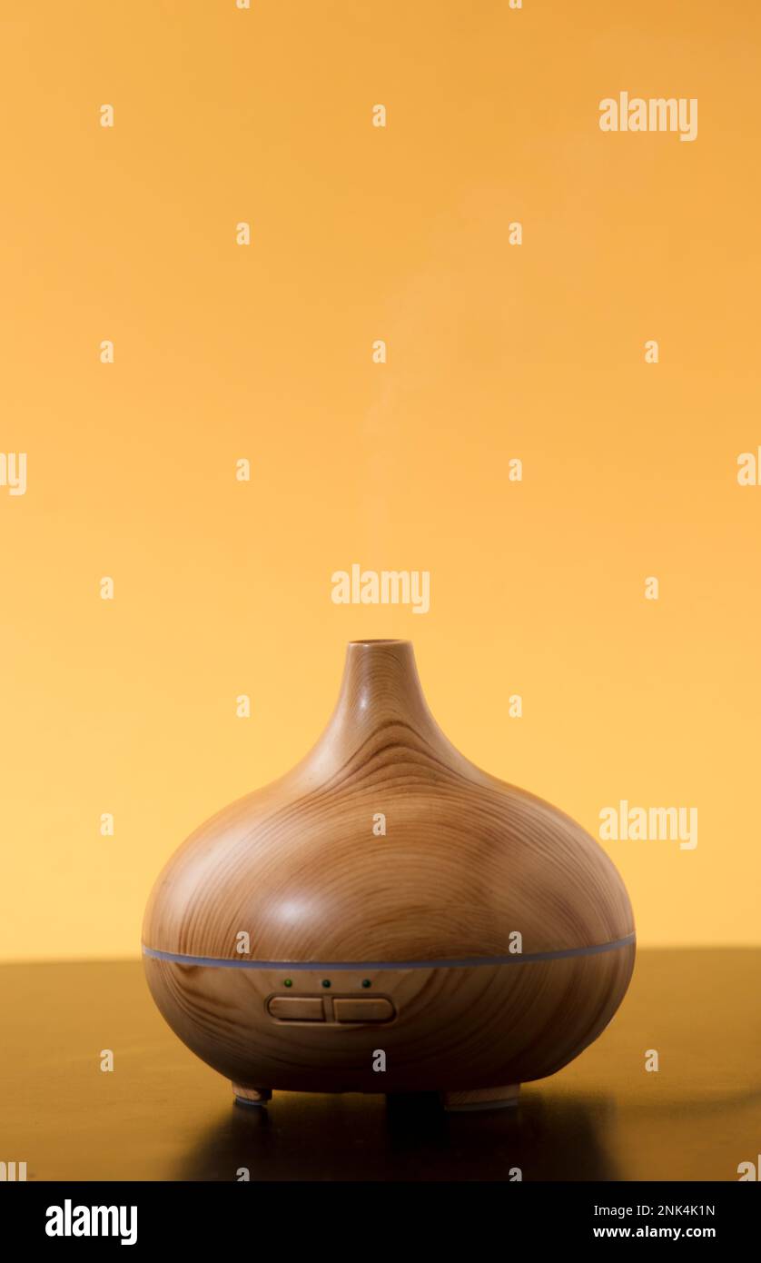 wooden air freshener with steam of natural oil essences, brown table ...