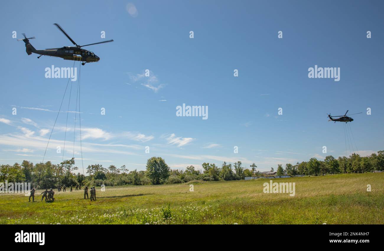 Two UH-60 Black Hawk helicopters hover as Soldiers rappel during Air Assault School at Fort ...