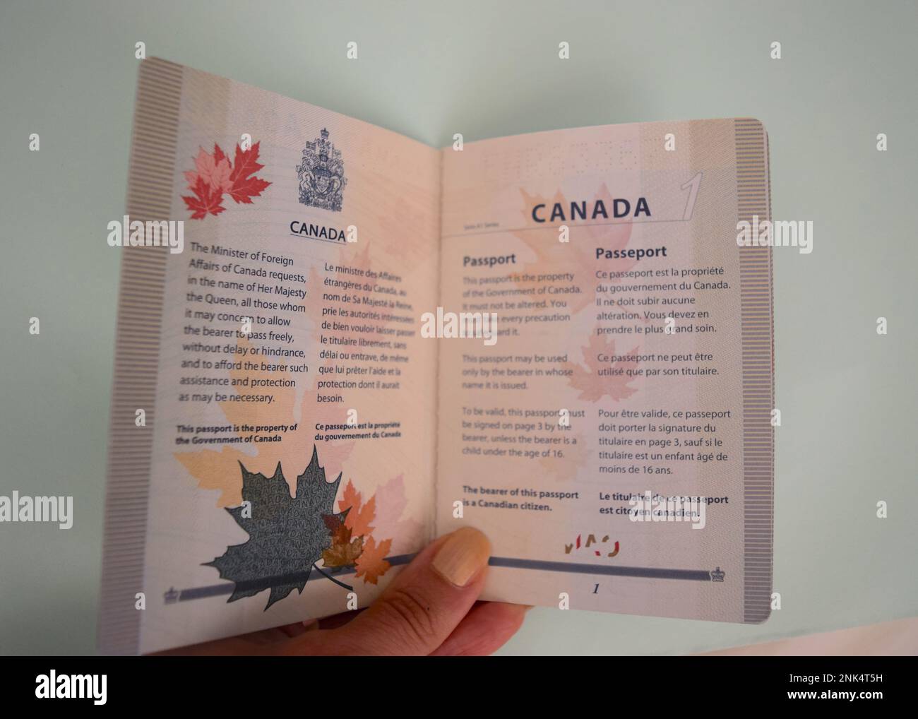 Canadian passport open on first page in hand Stock Photo - Alamy