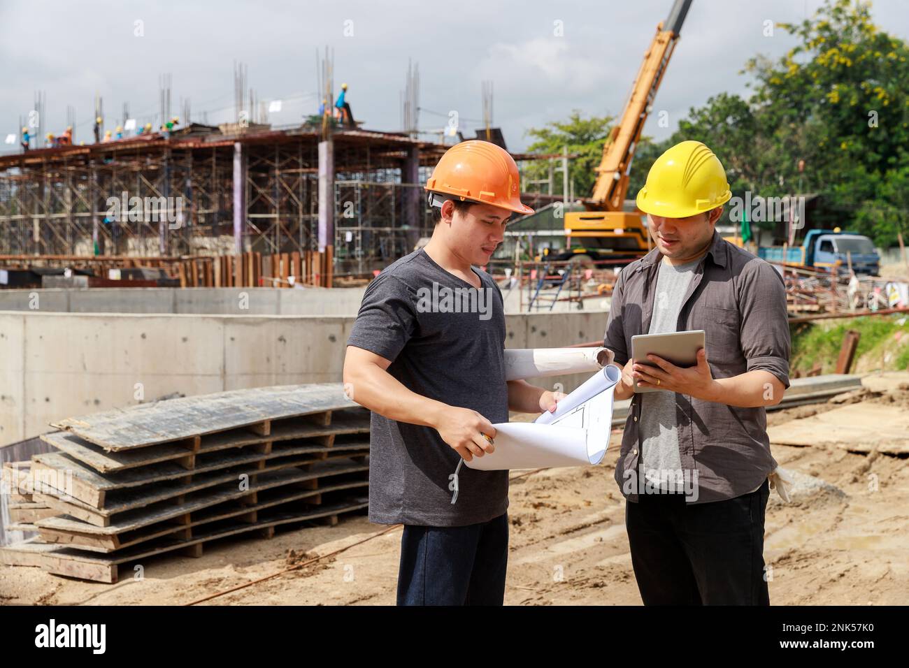 Team of construction workers discussing project details with blueprint ...