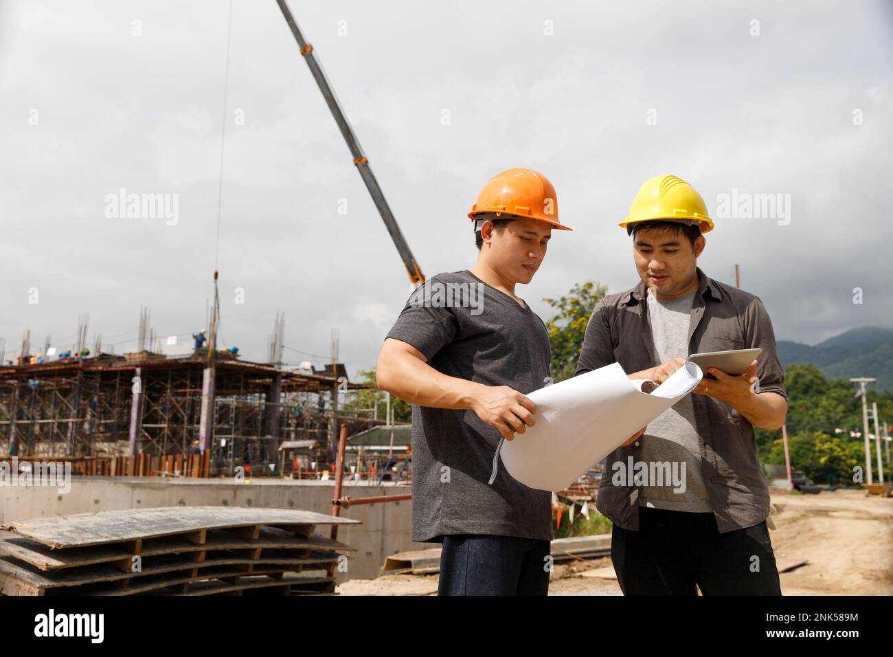 Team of construction workers discussing project details with blueprint ...