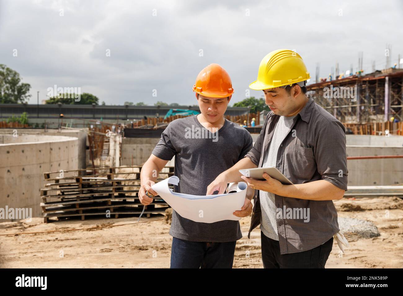 Team of construction workers discussing project details with blueprint ...