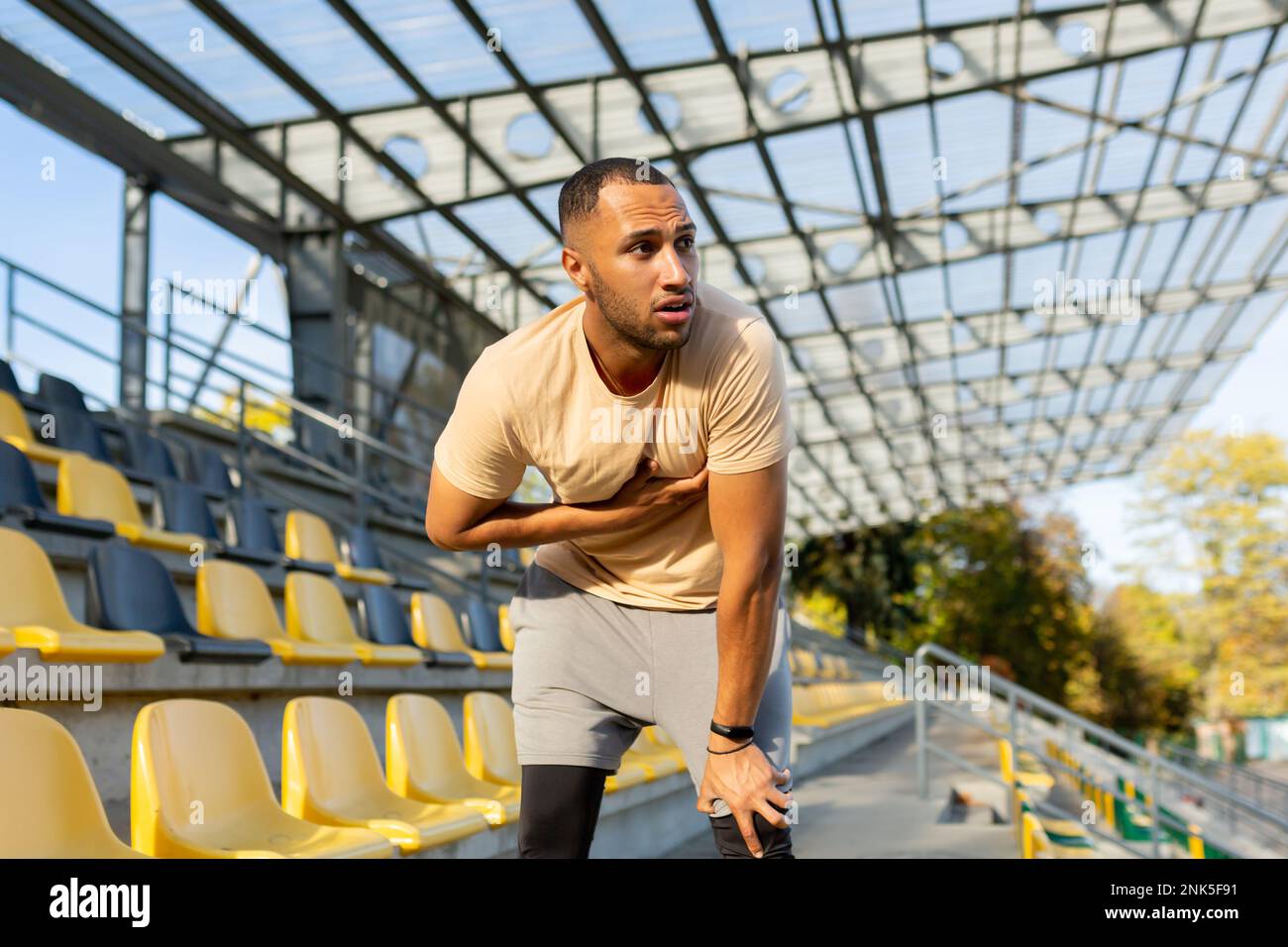 Young African American male sportsman, athlete, runner tired after ...