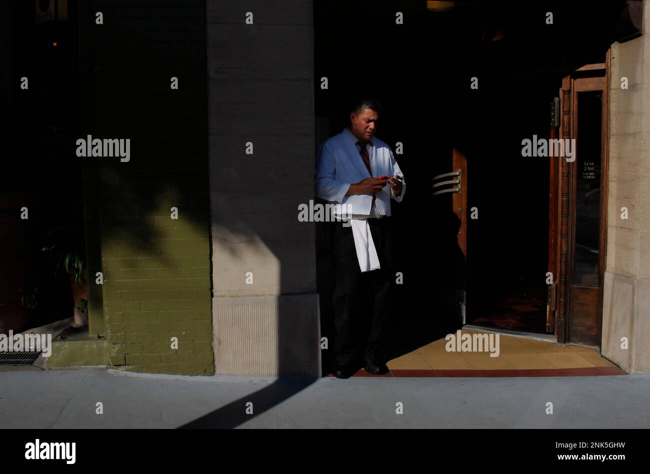 Ernie Evangelista, a bartenter at Tosca Cafe takes a break and checks ...