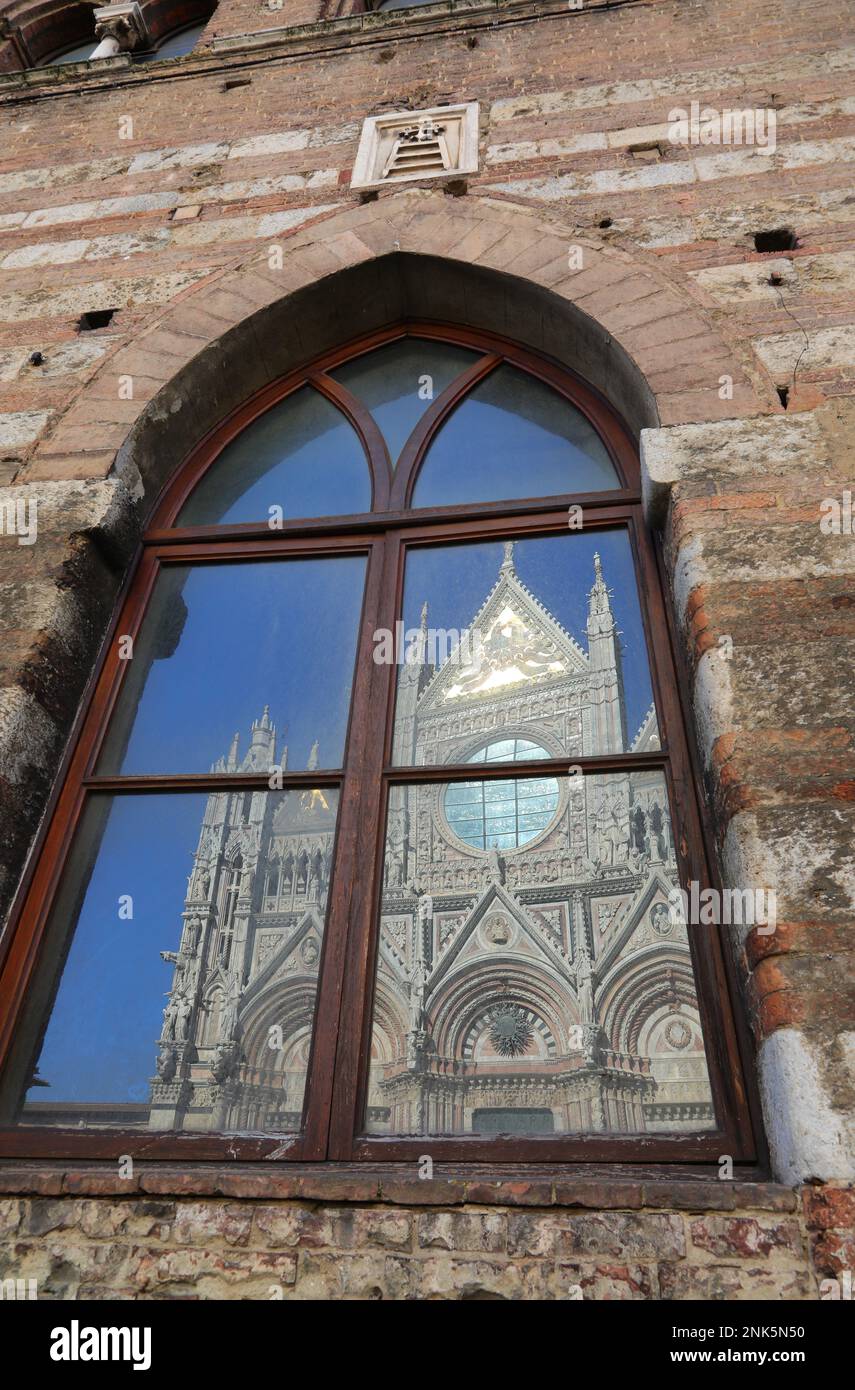 reflection on ancient window of the facade of Siena Cathedral in Italy ...