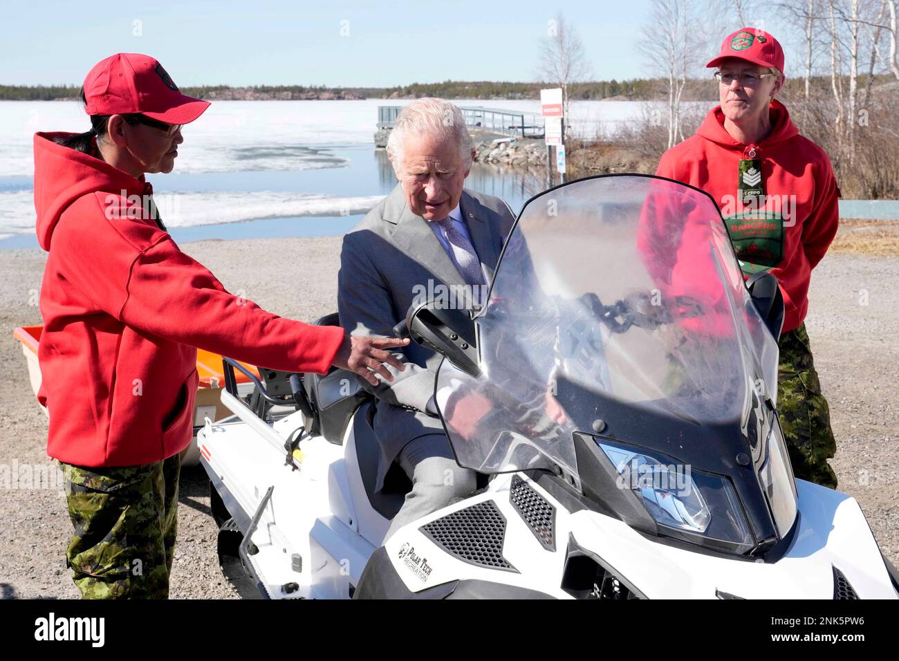 Prince Charles, center, is shown the operation of a snowmobile during a ...