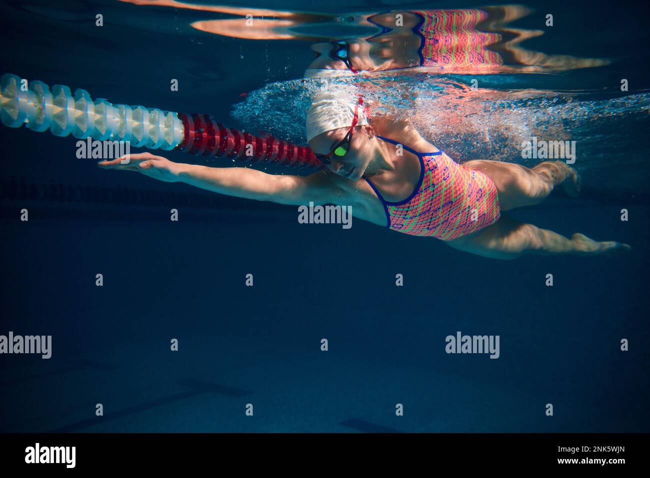 Coordination of movements. Professional female swimmer in cap and ...