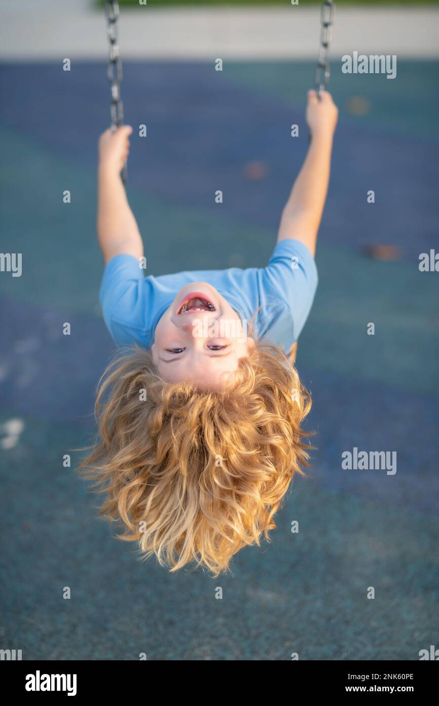 Child on swing playing on outdoor playground. Child boy exercise at ...
