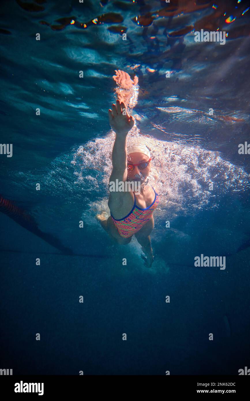 Depth. Dynamic shot of professional female swimmer training in swimming ...