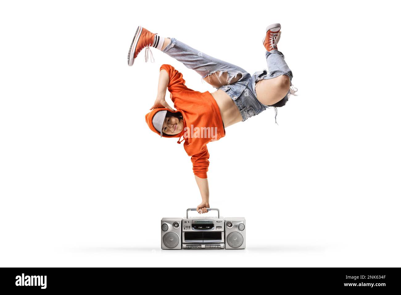 Young female performing a handstand with a boombox isolated on white ...