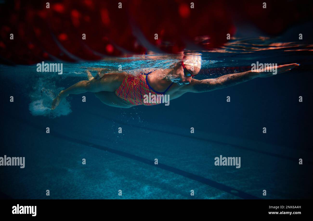 Young sportive woman, professional swimmer training in swimming pool ...