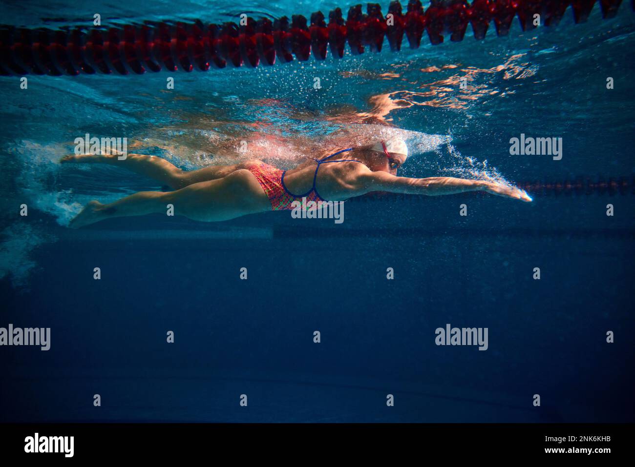 Side view dynamic image. Professional female swimmer training in ...