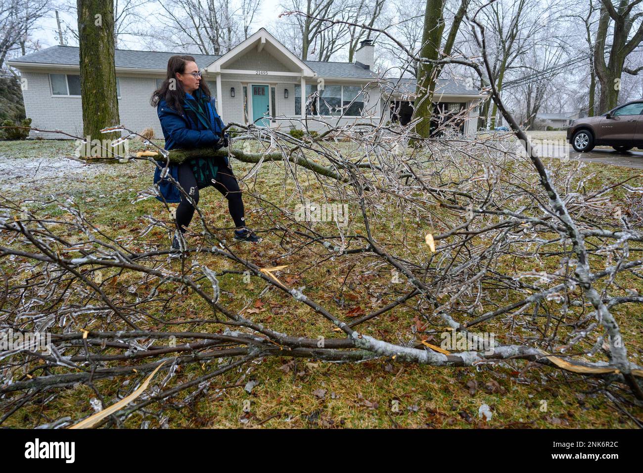 Kathleen Nachtrab moves broken tree branches to the curb after ice ...