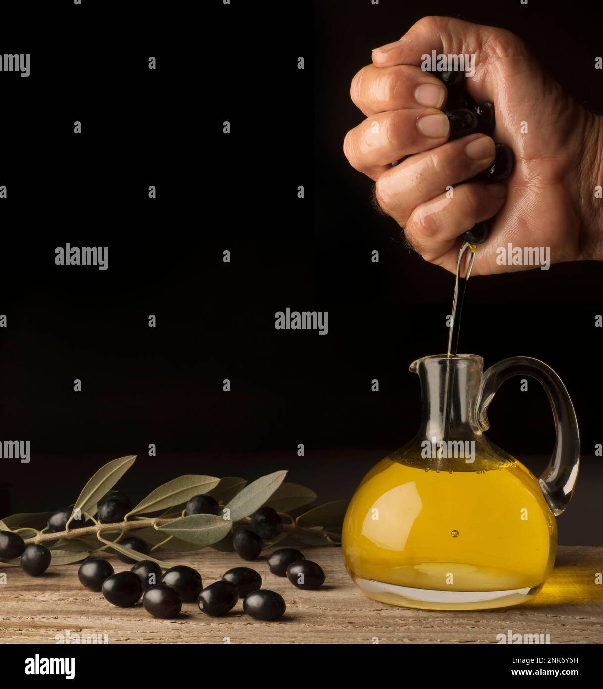 pressing of olives with hand Stock Photo - Alamy