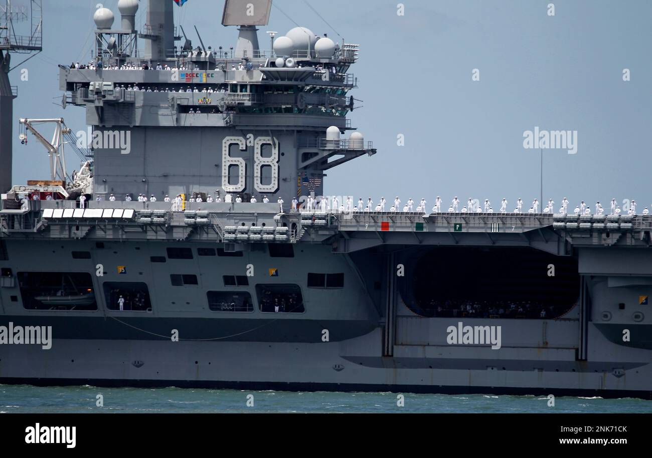 Sailors stand at attention on all decks of the USS Nimitz as the ...