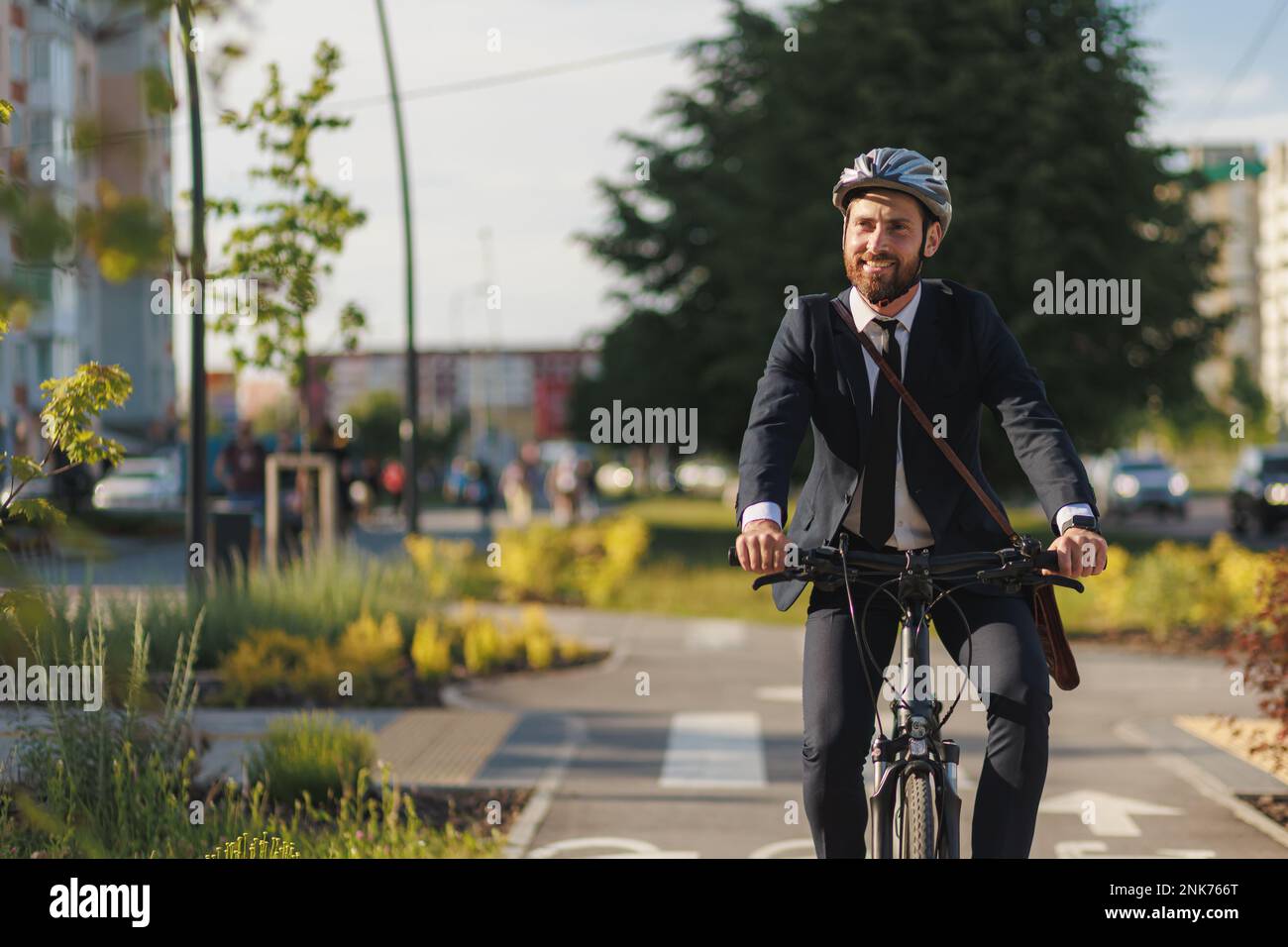 Happy office worker in elegant apparel, riding on cycle path in city ...