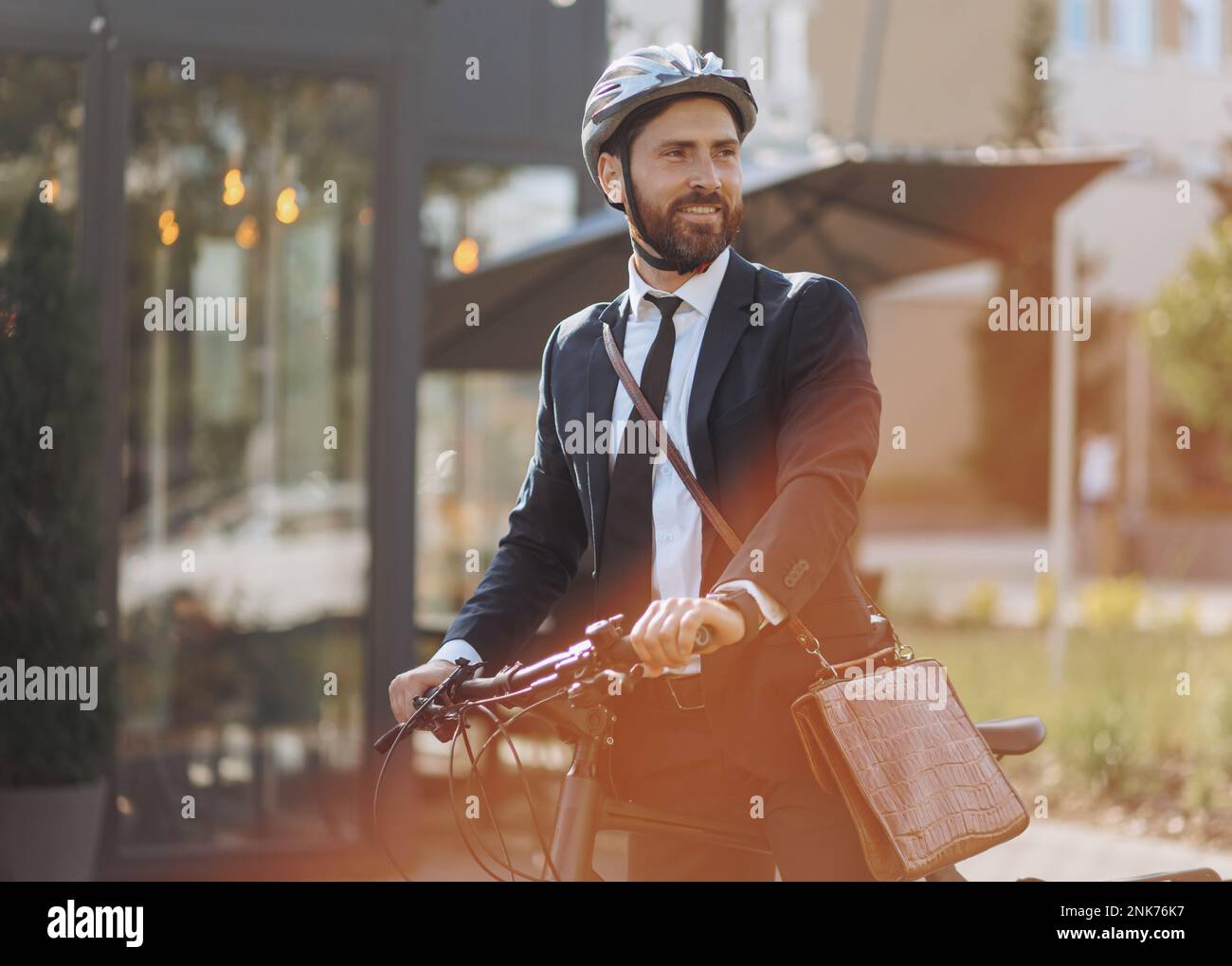 Happy employee in blazer stopping, while riding after work in downtown ...