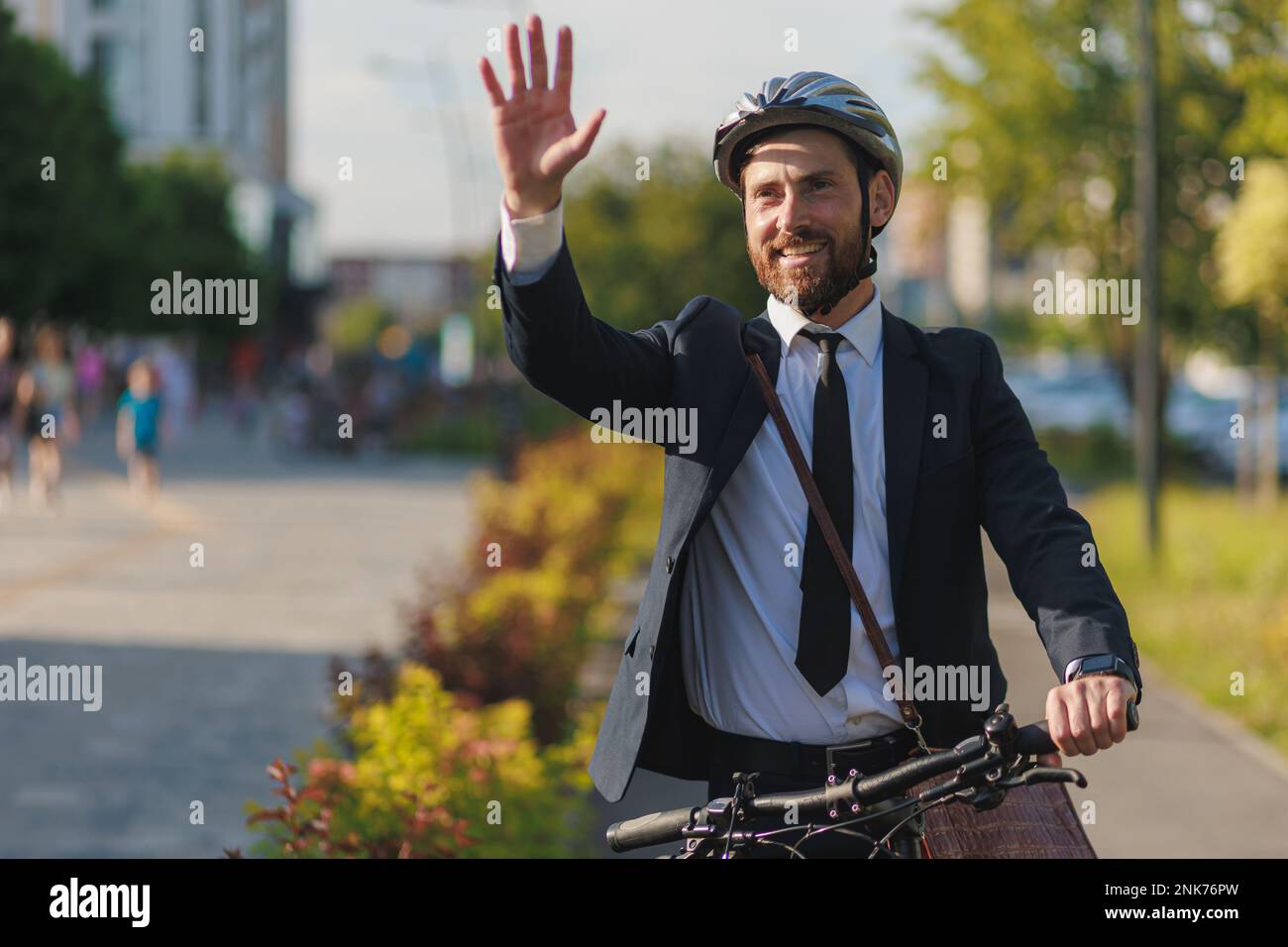 Cheerful male businessman gesturing hi to workmate on street. Front ...