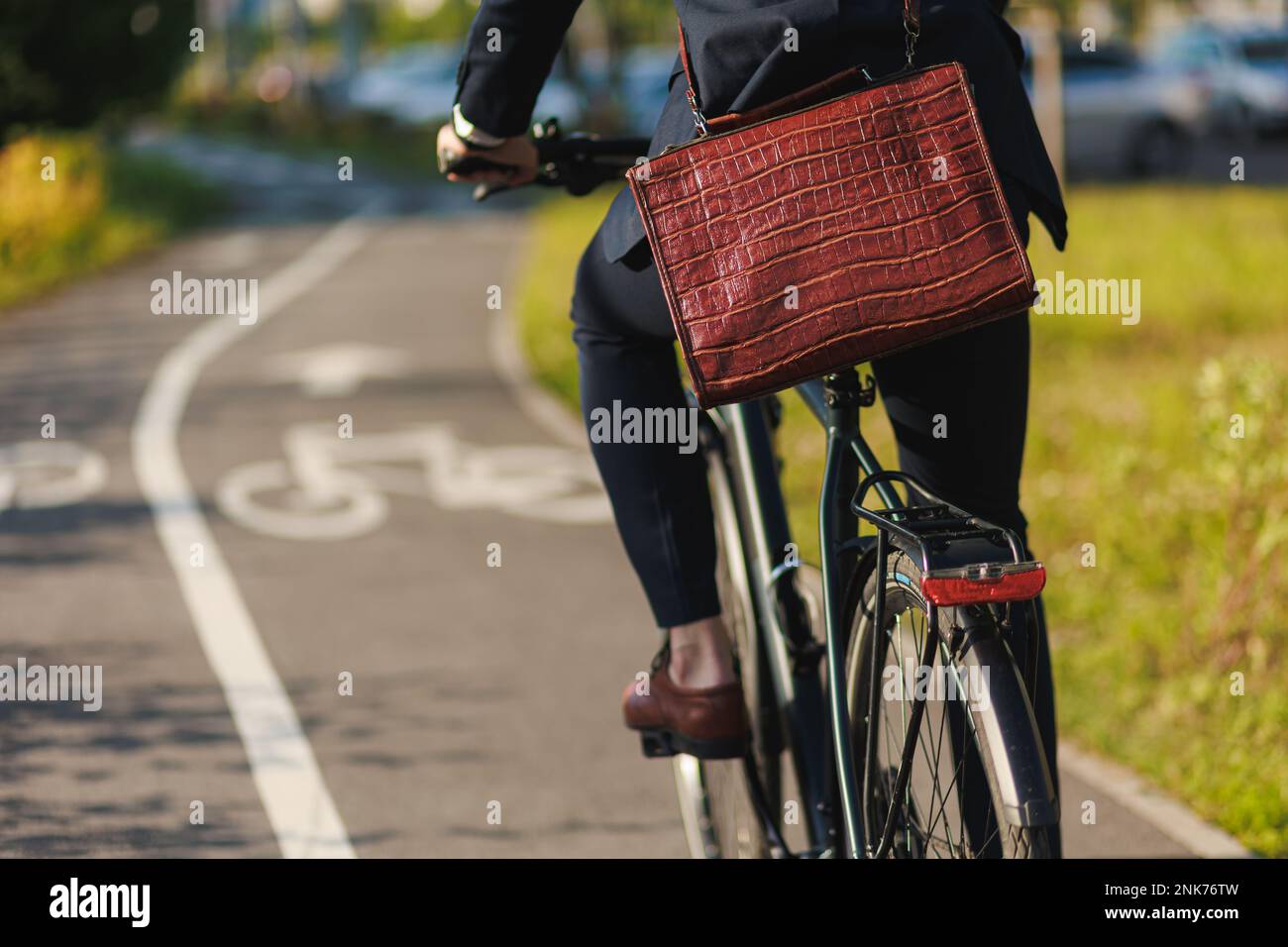 Crop view of anonymous male manager in fashioned suit riding on bike ...