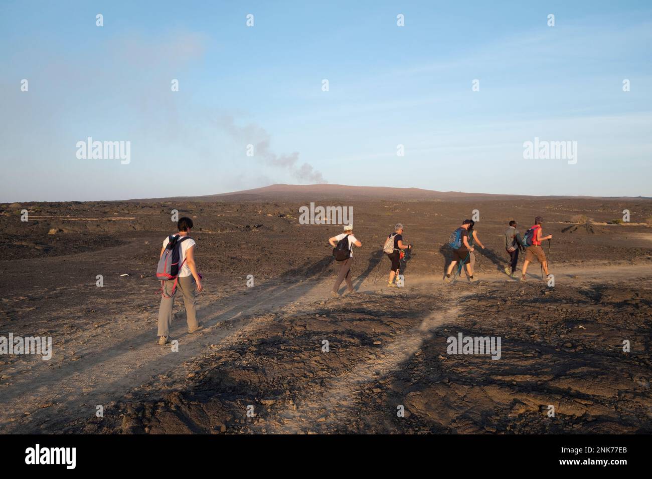 Tourists with backpack walking across lava fields during the daytime at ...