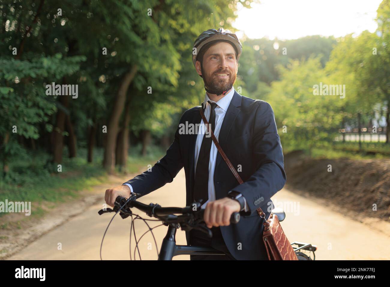 Handsome male manager enjoying landscape, while riding on bike to ...