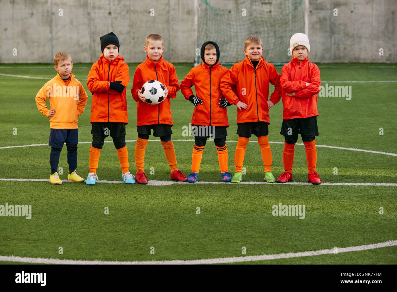 Group of boys, children, football players in uniform standing in a line ...