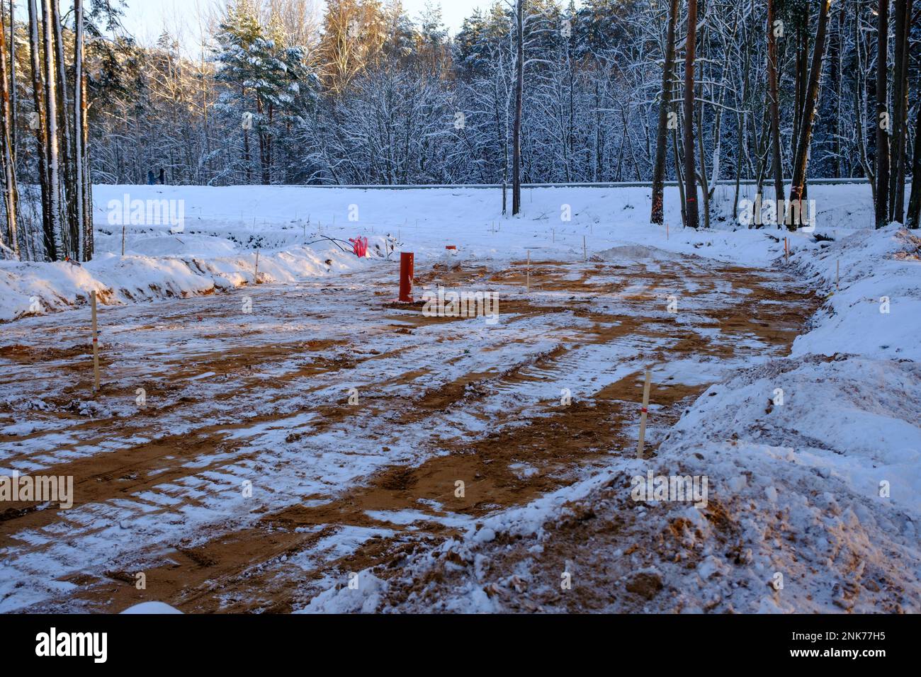 New road construction site in the forest in winter with snow and mud ...