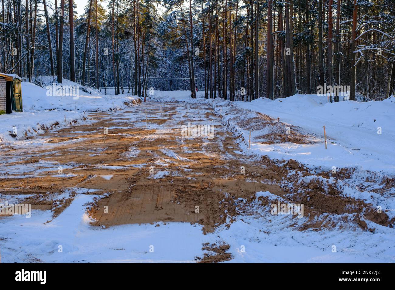 New road construction site in the forest in winter with snow and mud ...