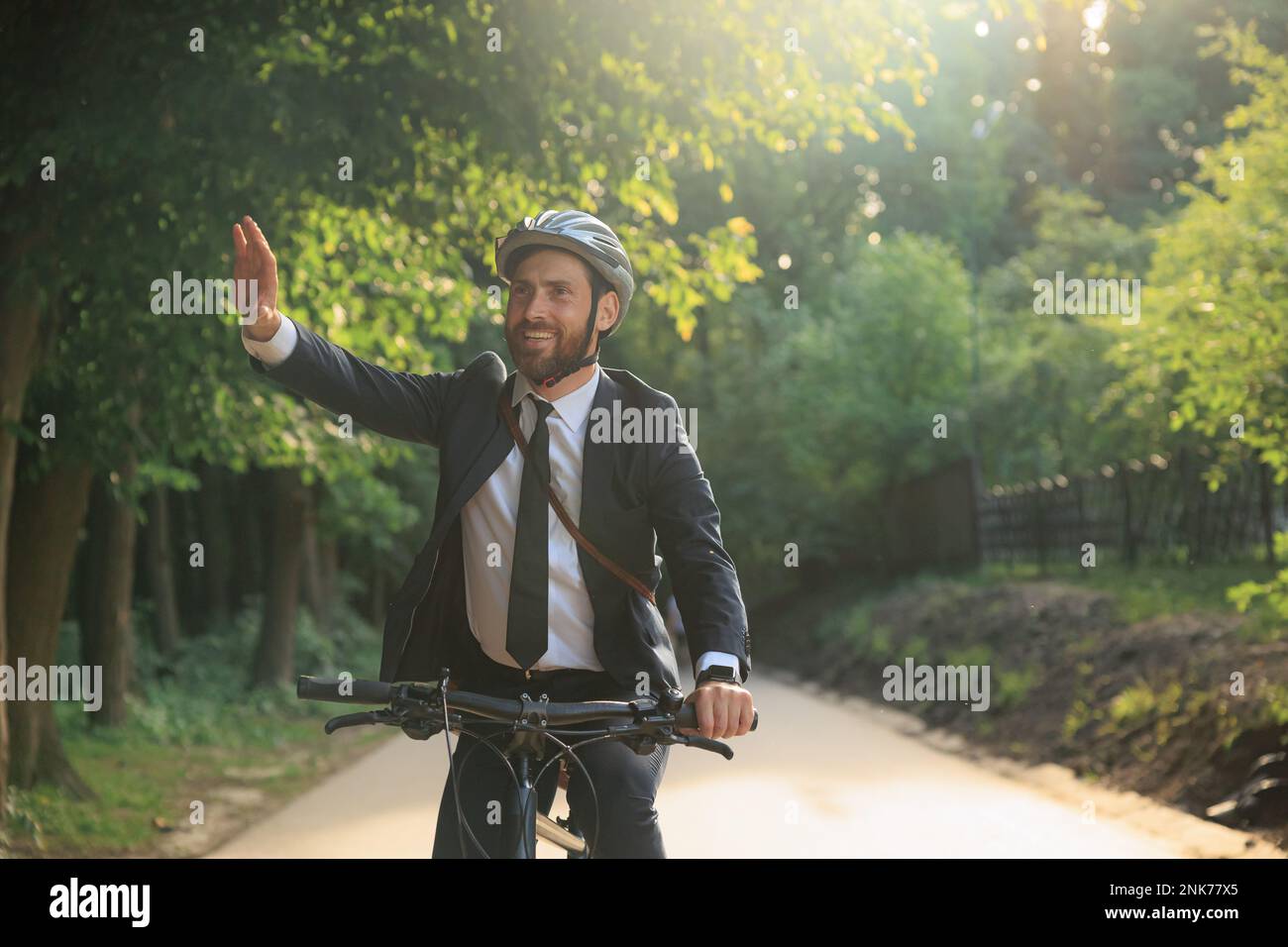Smiling male businessman saying goodbye to workmate after job outdoors ...