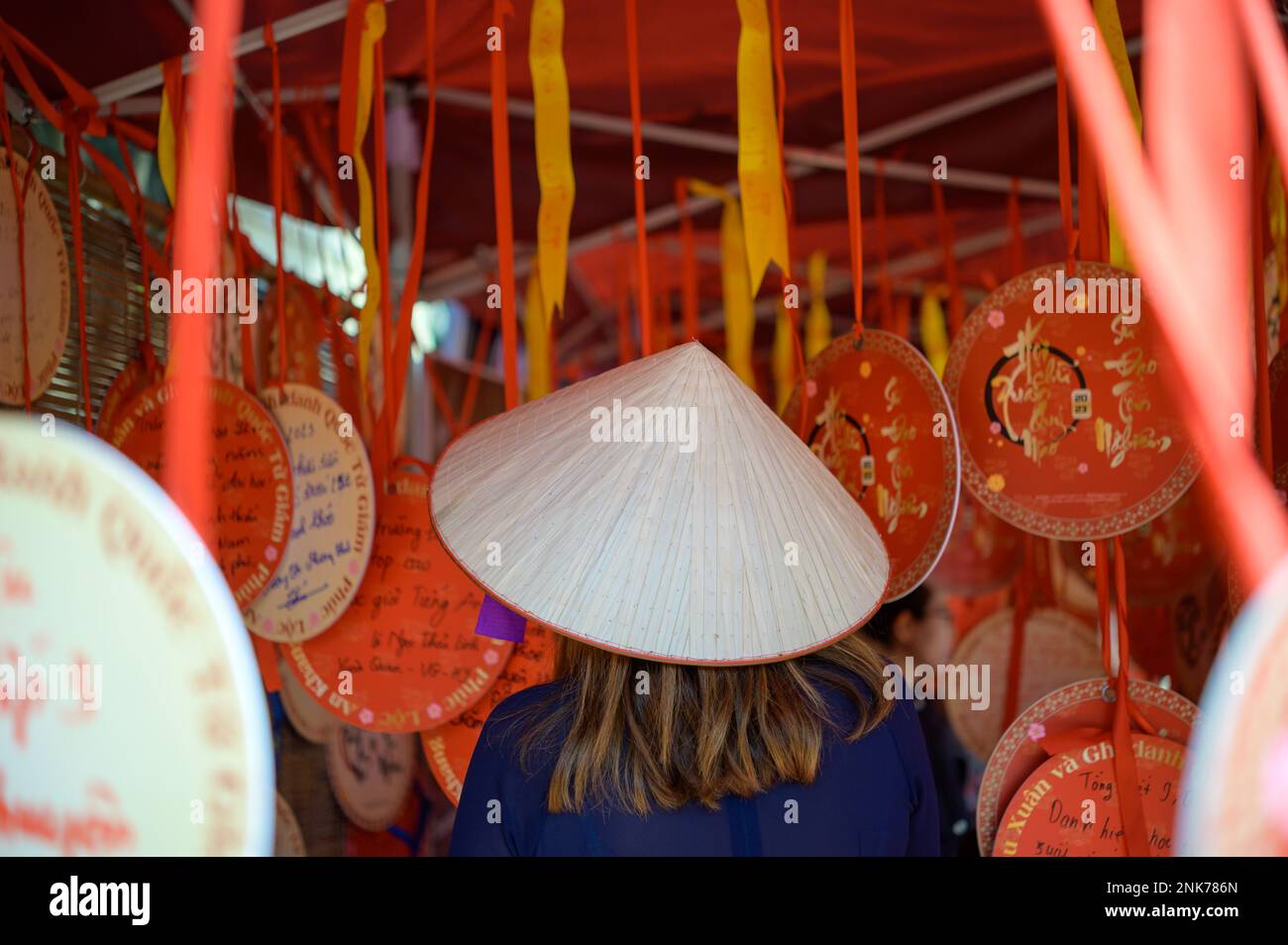Back view of unrecognizable female tourist in Asian conical hat ...