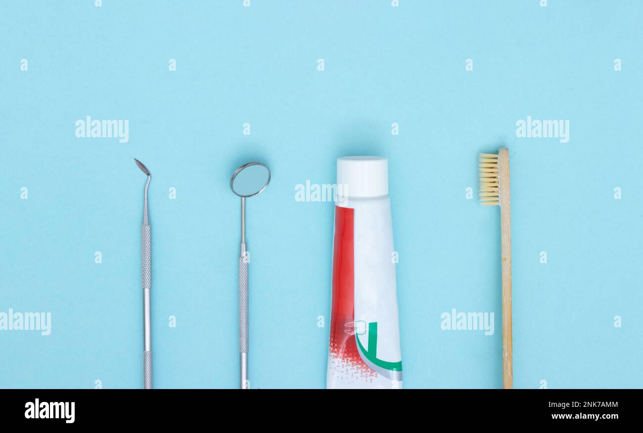 Different tools for dental care, toothbrush and toothpaste on blue ...