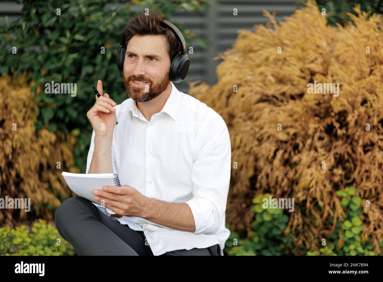 Joyful manager in white shirt raising index finger up during generation ...
